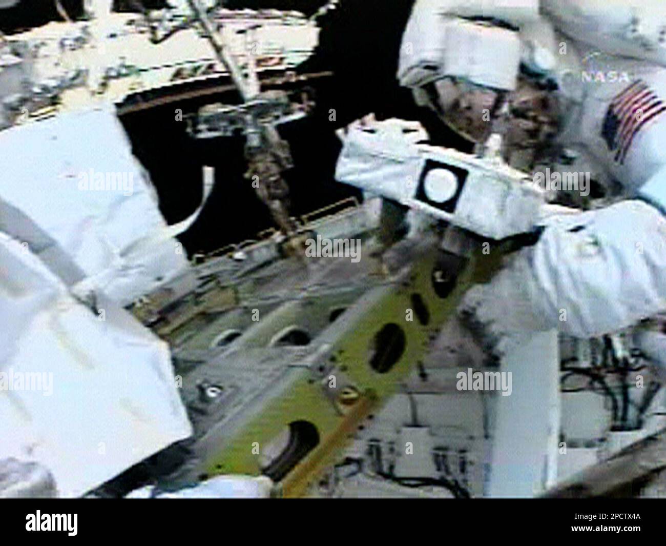 In this image made from NASA TV, astronaut Piers Sellers works in ...