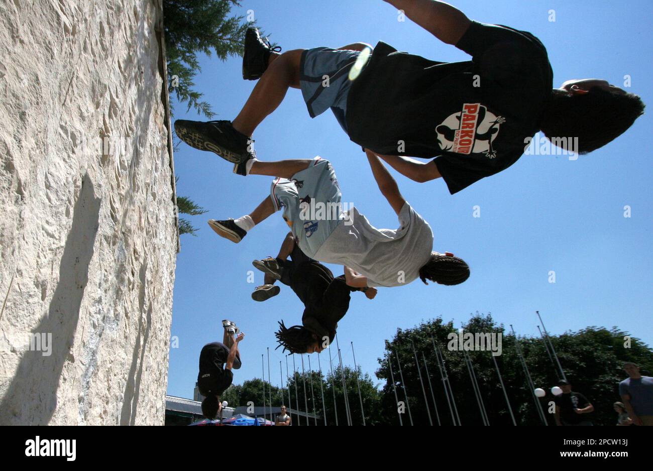 Bulgarian Yamakasi fans jump as they perform a somersault during a ...