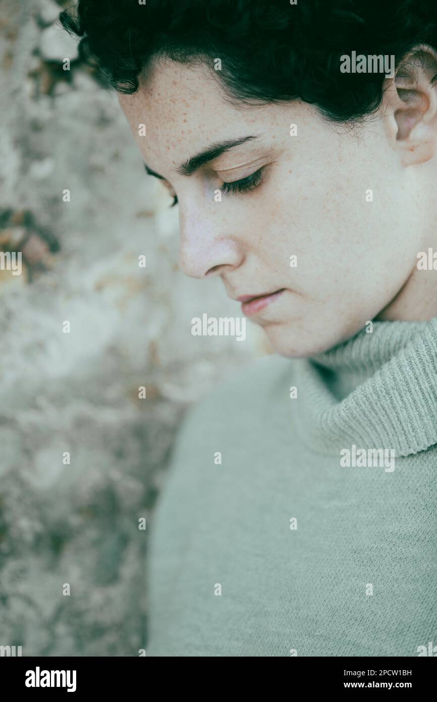 Side view of a beautiful sad woman looking down Stock Photo - Alamy