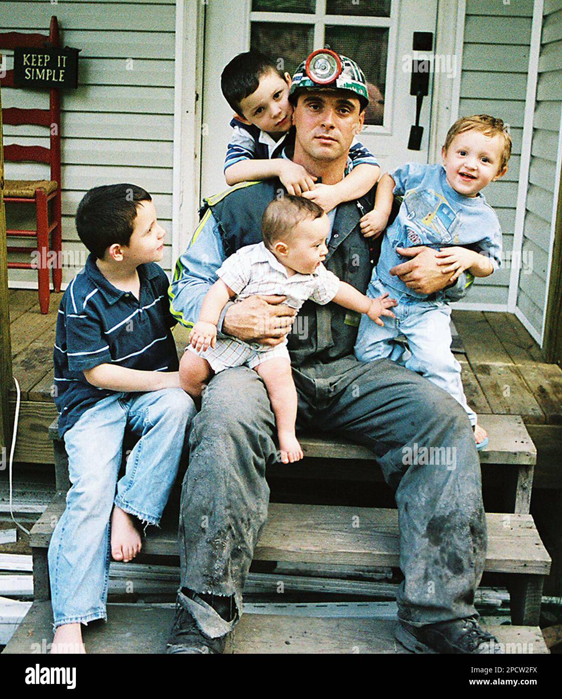 Allen Turner sits on his porch with his four children, clockwise from ...