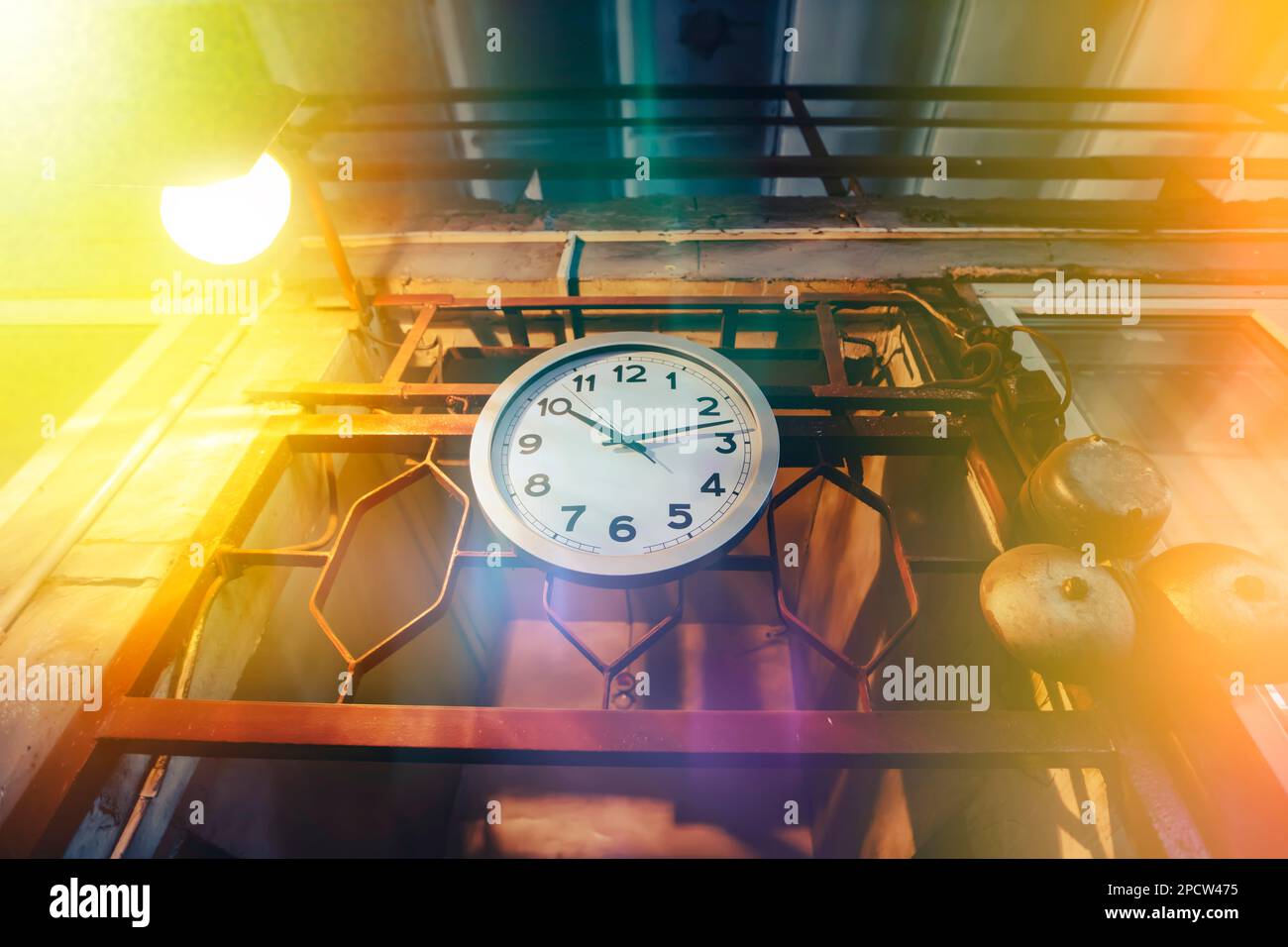 Clock in a multi-colored gradient on old metal supports. Time is ...