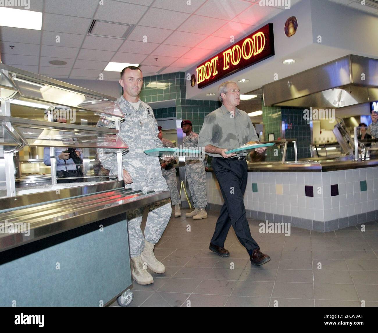 President Bush carries his food plate to his seat at the cafeteria ...