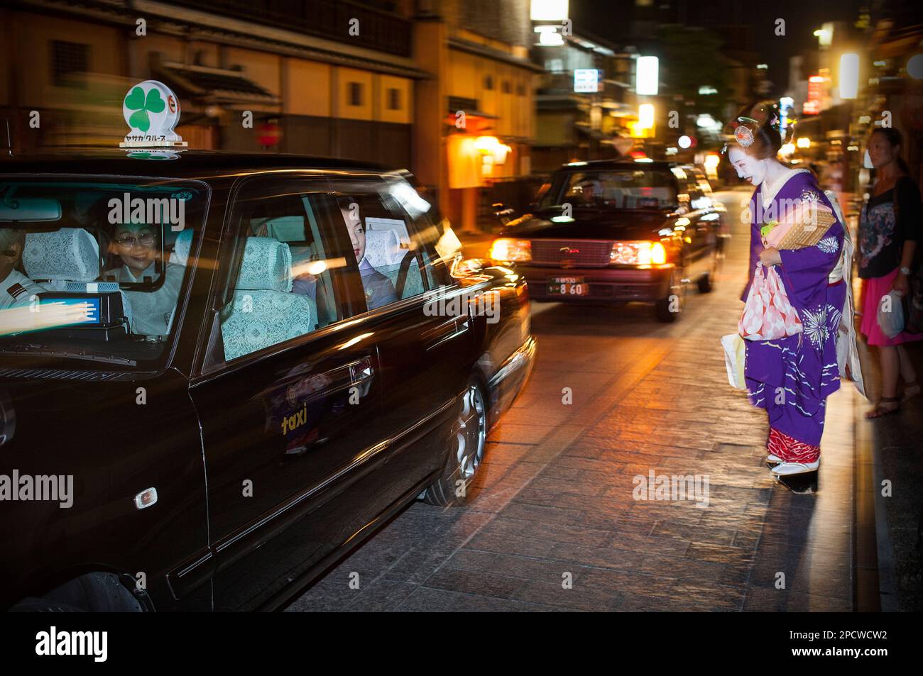 Geisha says goodbye to occupants of a taxi in Hanamikoji dori street ...