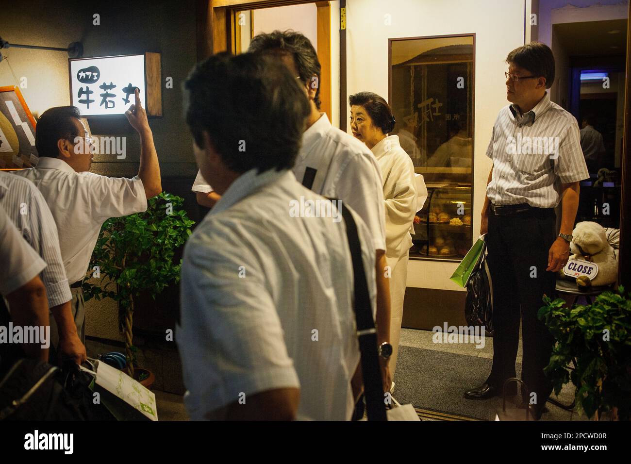 Oka san says goodbye to clients.In Hanamikoji dori street.Geisha's ...