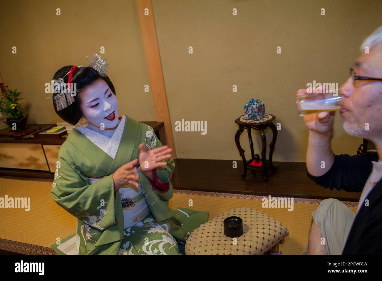 Fukukimi,'maiko' (geisha apprentice) workimg (joking with a client) in ...