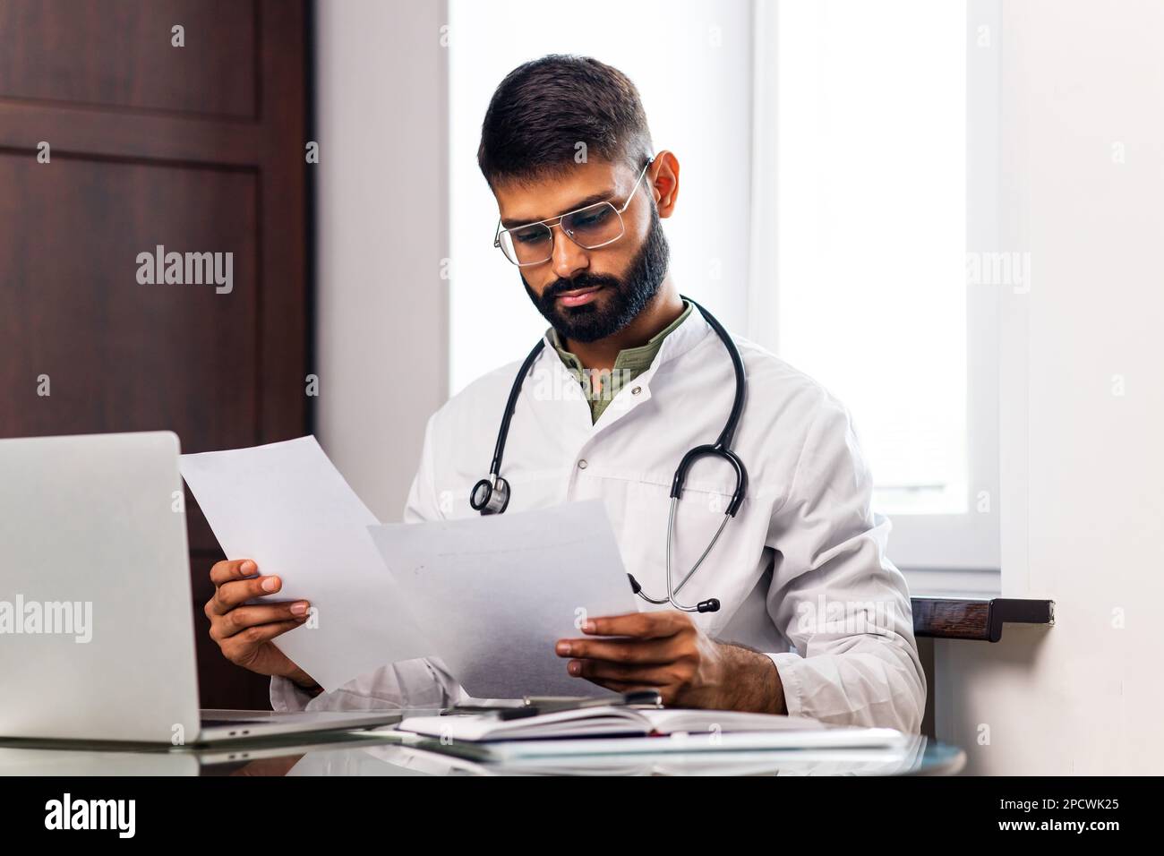 indian doctor wearing uniform taking notes in medical documents Stock ...