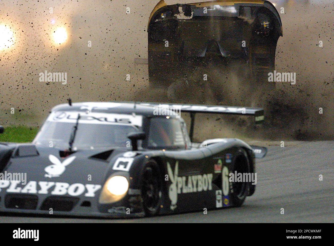 The No. six Playboy auto racing car roars past the No. 89 Vonage ...