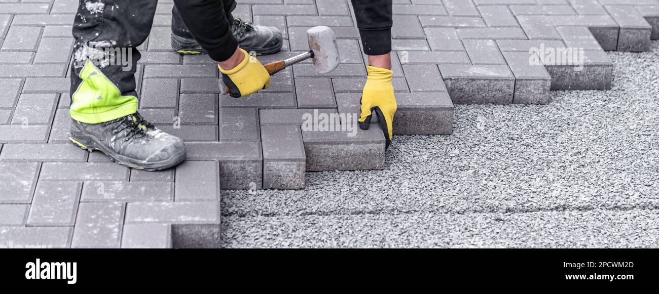 rubber hammer for adjusting the lock paving on the sidewalk. banner ...