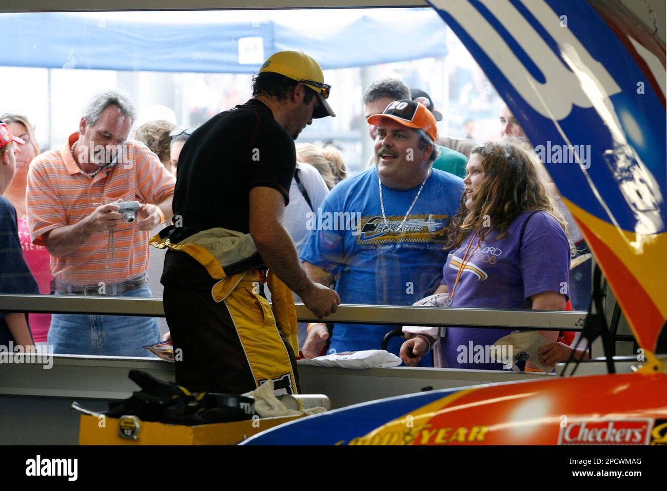NASCAR driver Elliott Sadler( back to camera), in his garage, signs ...