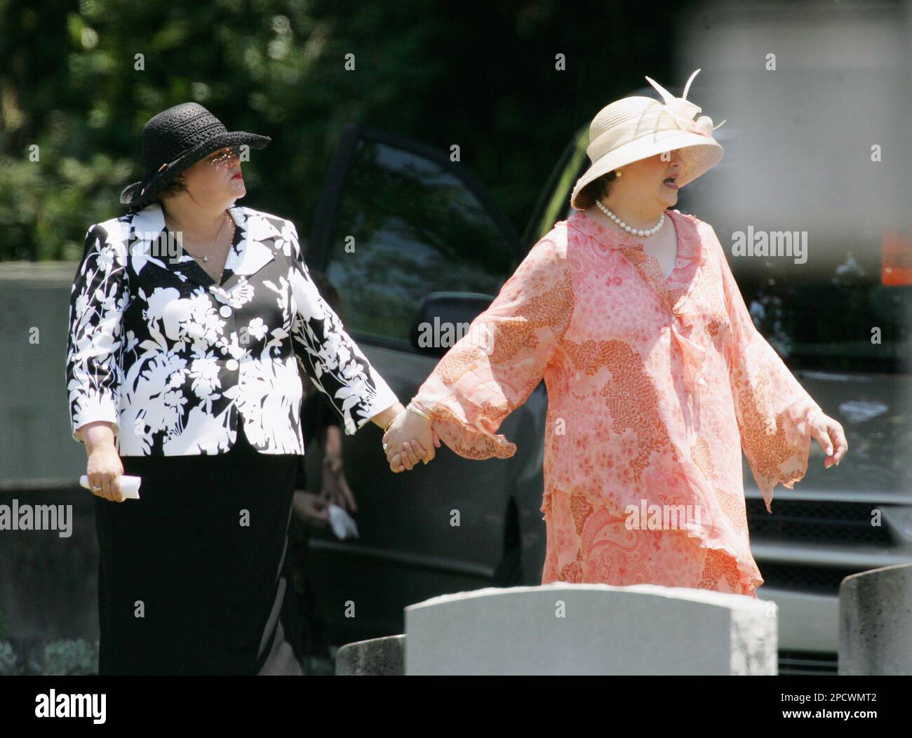 Paulette Paugh Davis, left, and Pam Paugh grasp hands during services ...
