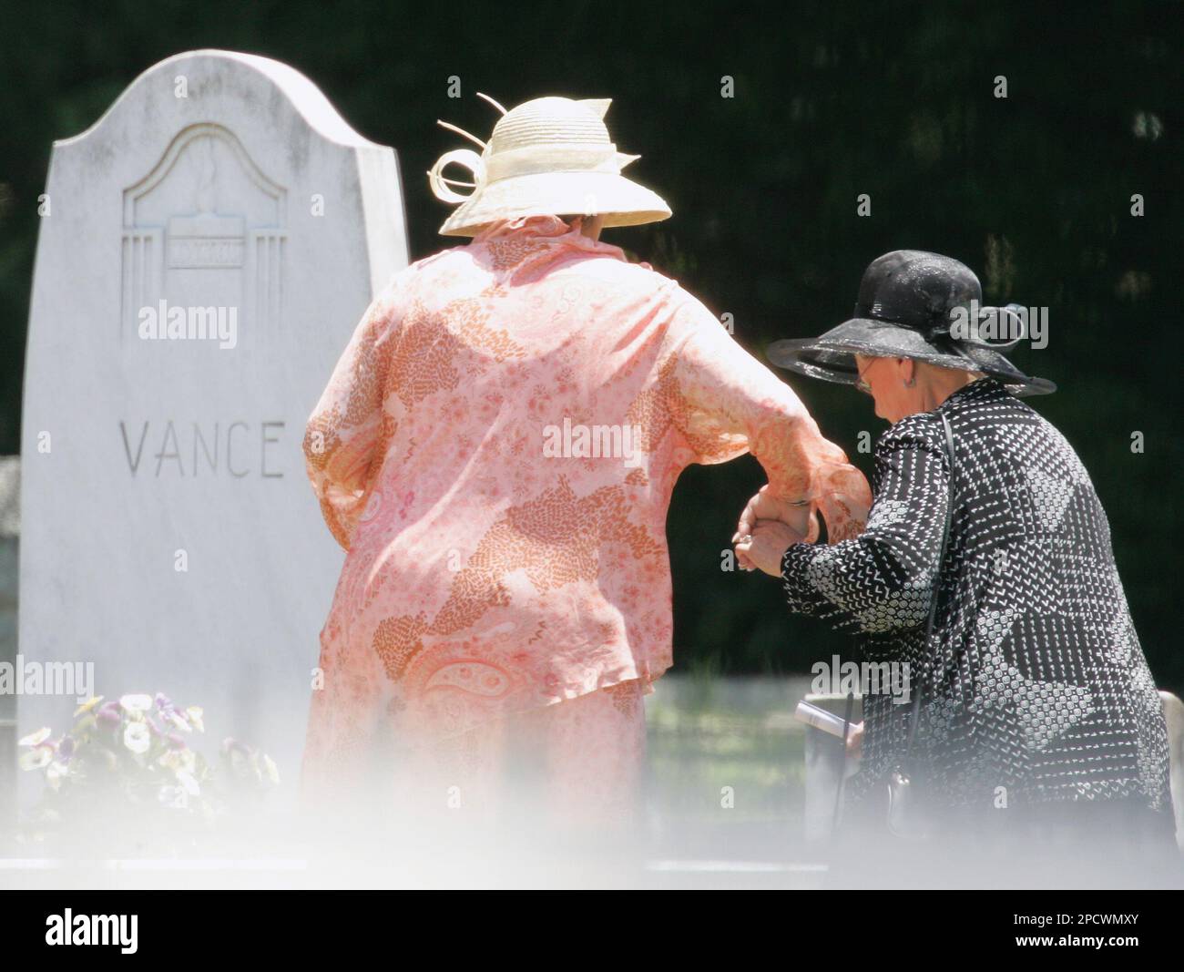 Pam Paugh, left, sister of Patsy Ramsey, assists another attendee ...