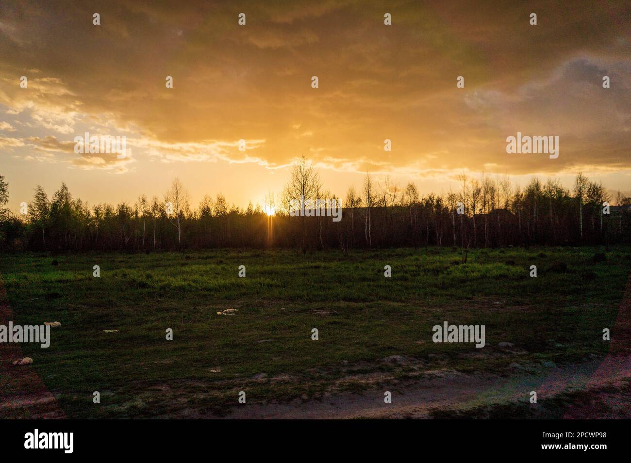 Green meadow under sunset sky with clouds Stock Photo - Alamy