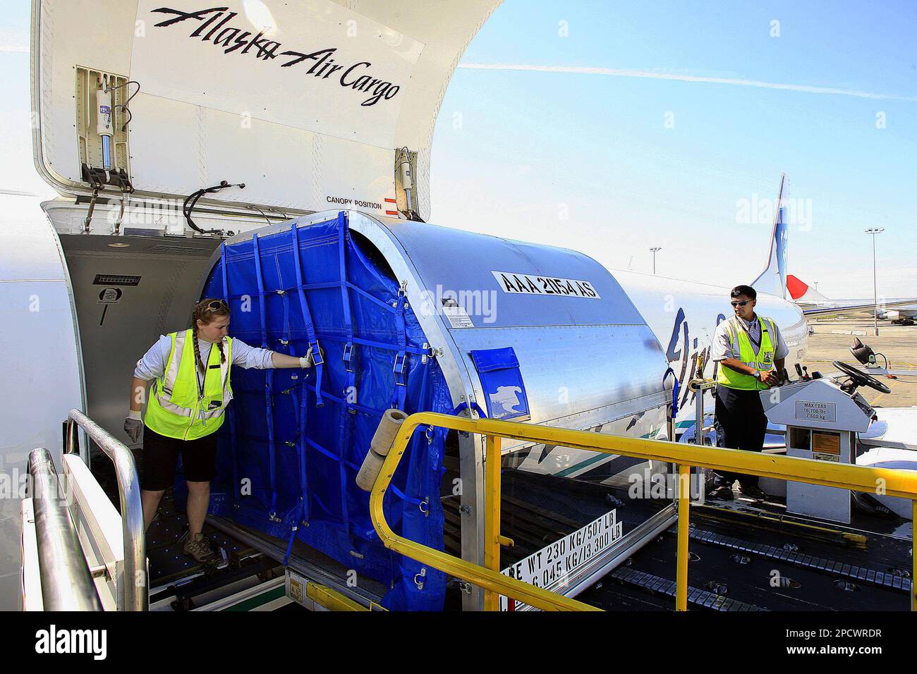 Alaska Airlines cargo handlers demonstrate how they load a retrofitted ...