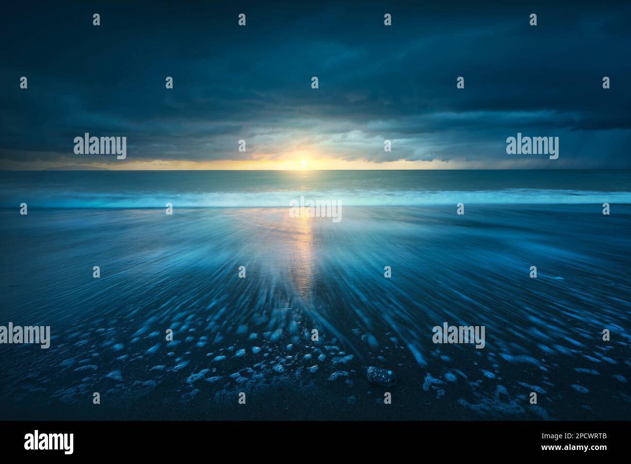 Sea at sunset after the thunderstorm. A long wave and a stone on the ...