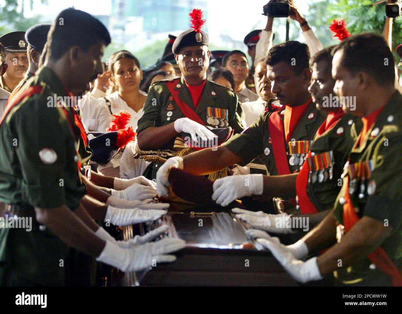 Sri Lankan army soldiers fold the Sri Lankan flag during the funeral of ...