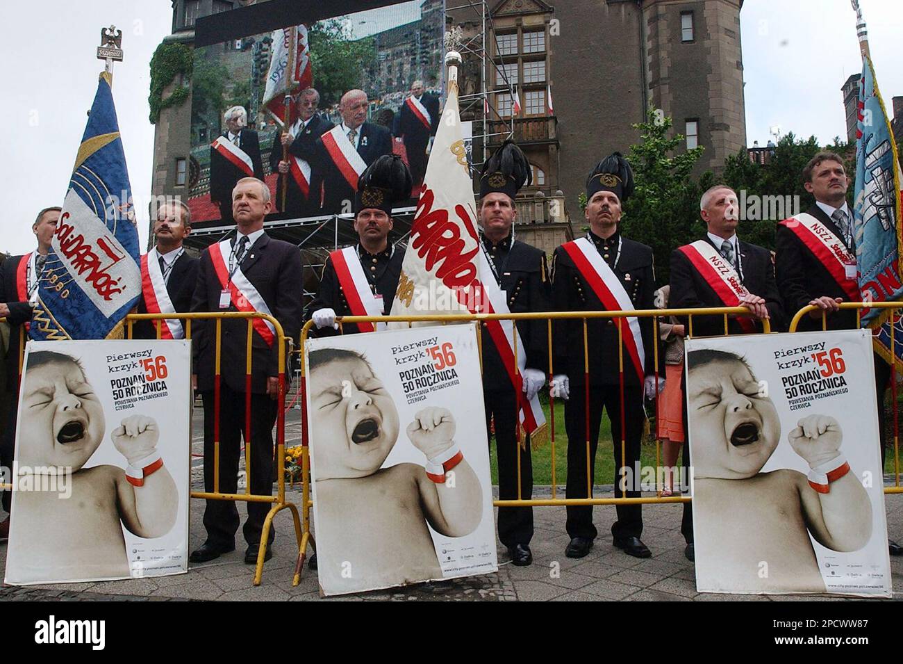 Polish men stand with solidarity banners at a Mass marking the 50th ...