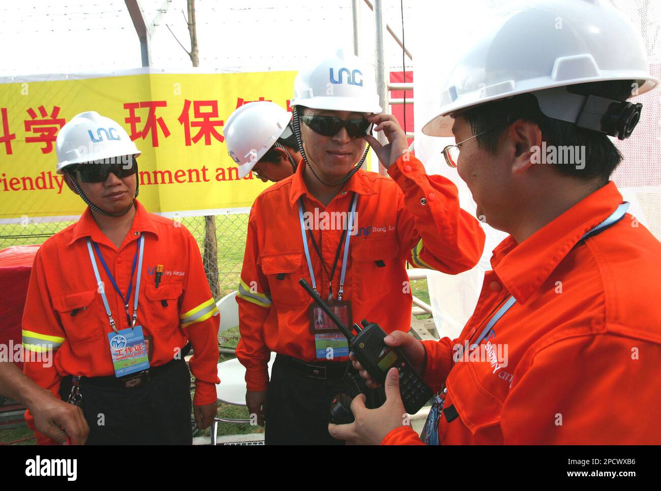 Workers wait after a ceremony marking the beginning of deliveries of ...
