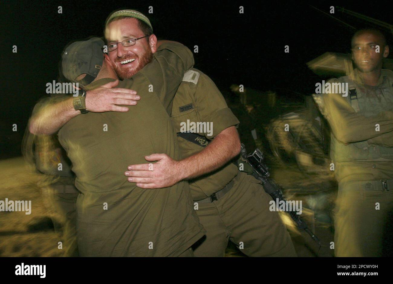 Israeli soldiers hug each other before moving into the Gaza Strip at an ...