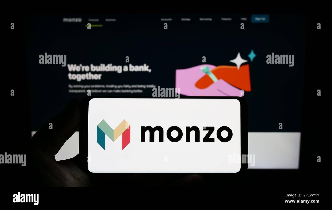 Person holding smartphone with logo of British banking company Monzo ...