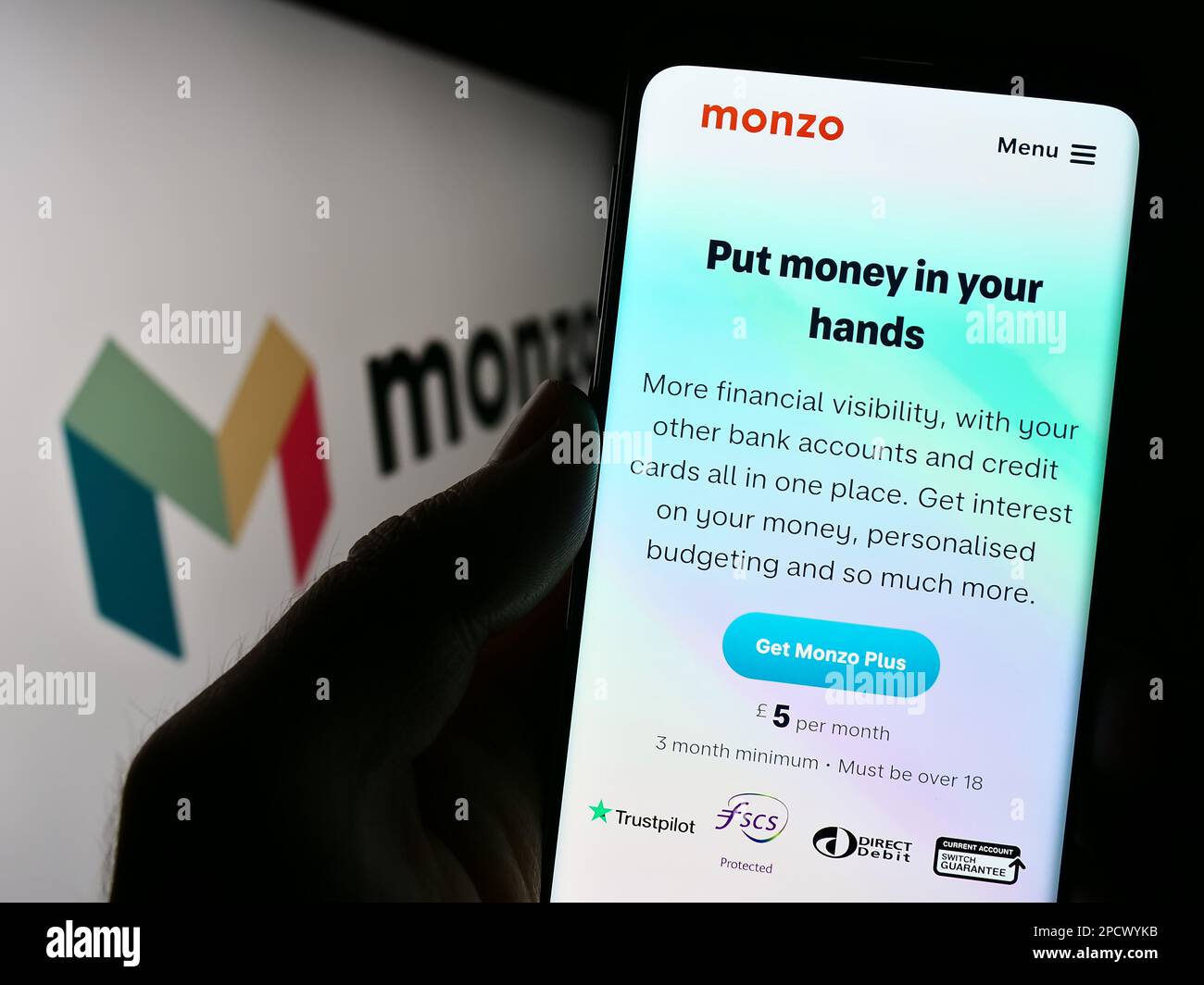 Person holding smartphone with web page of British banking company ...