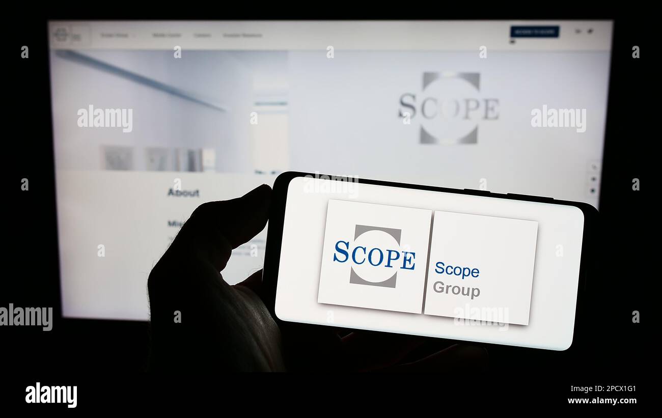 Person holding cellphone with logo of European fund rating company ...