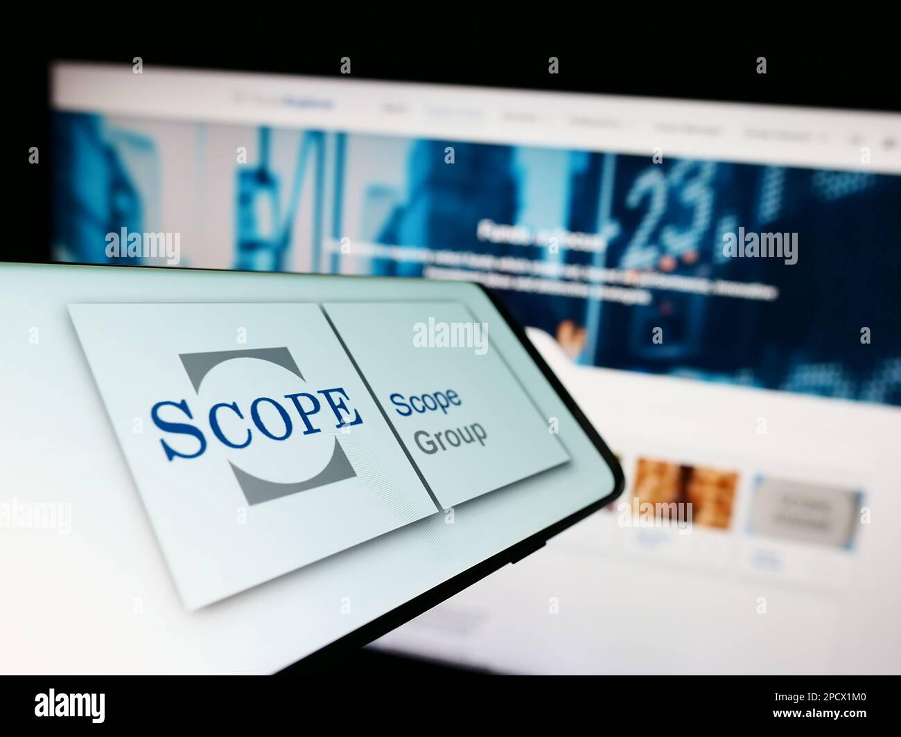 Mobile phone with logo of European fund rating company Scope Group on screen in front of ...