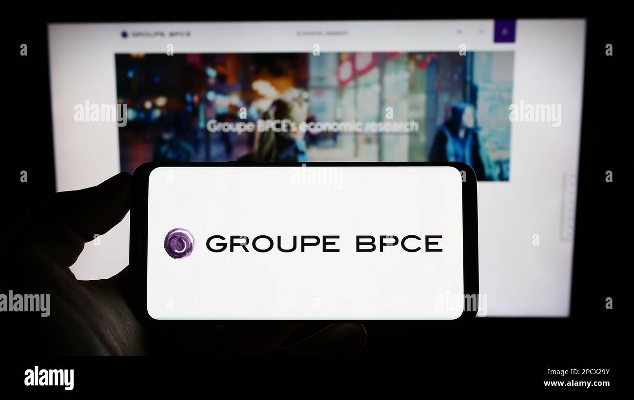 Person holding cellphone with logo of French banking company Groupe ...