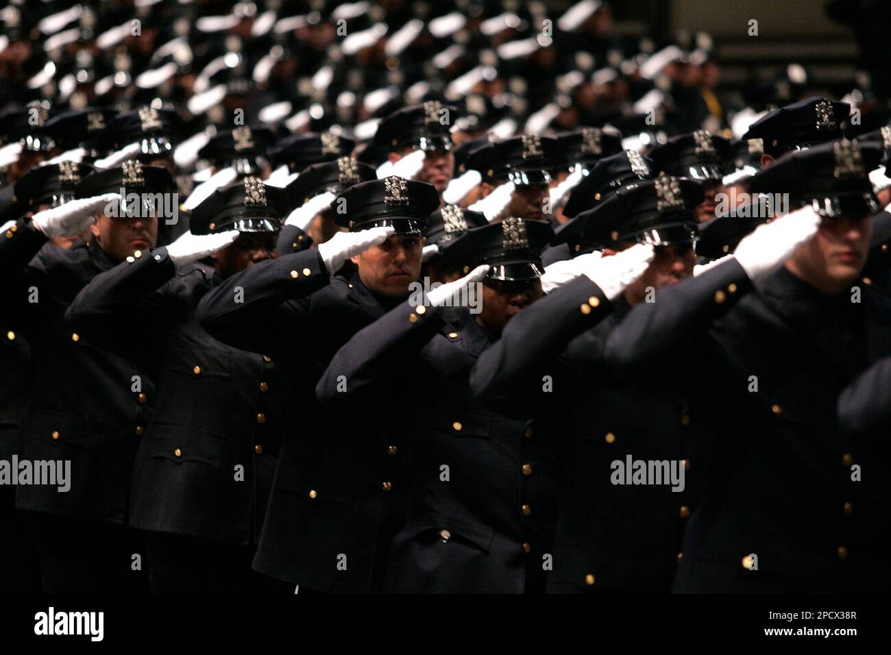 Police academy graduates salute during a graduation ceremony, Monday ...