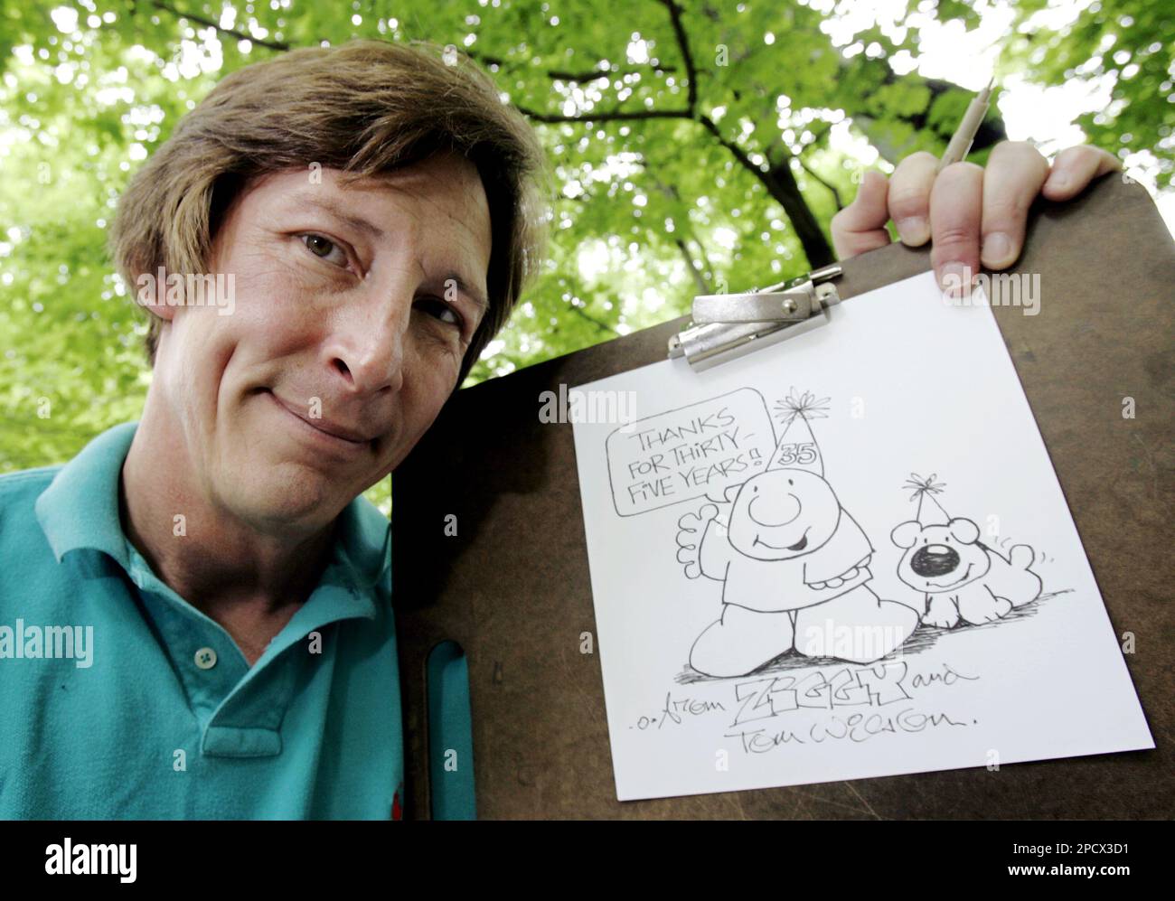 Artist Tom Wilson holds a Ziggy cartoon celebrating the strip's 35th ...