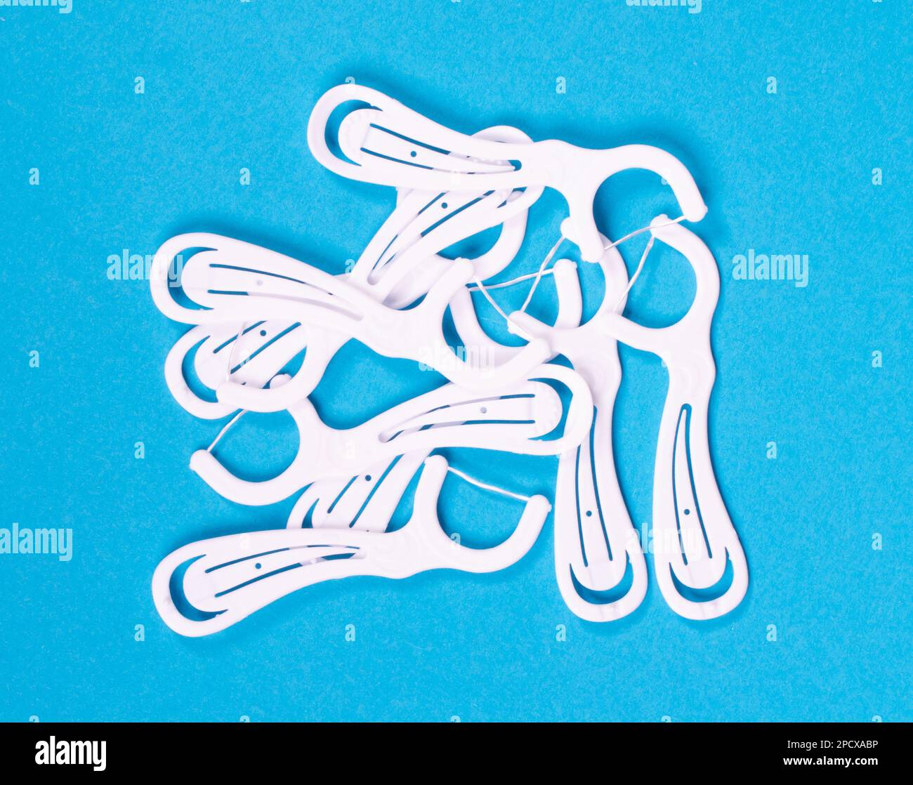 White toothpicks with floss isolated with clipping path over blue ...