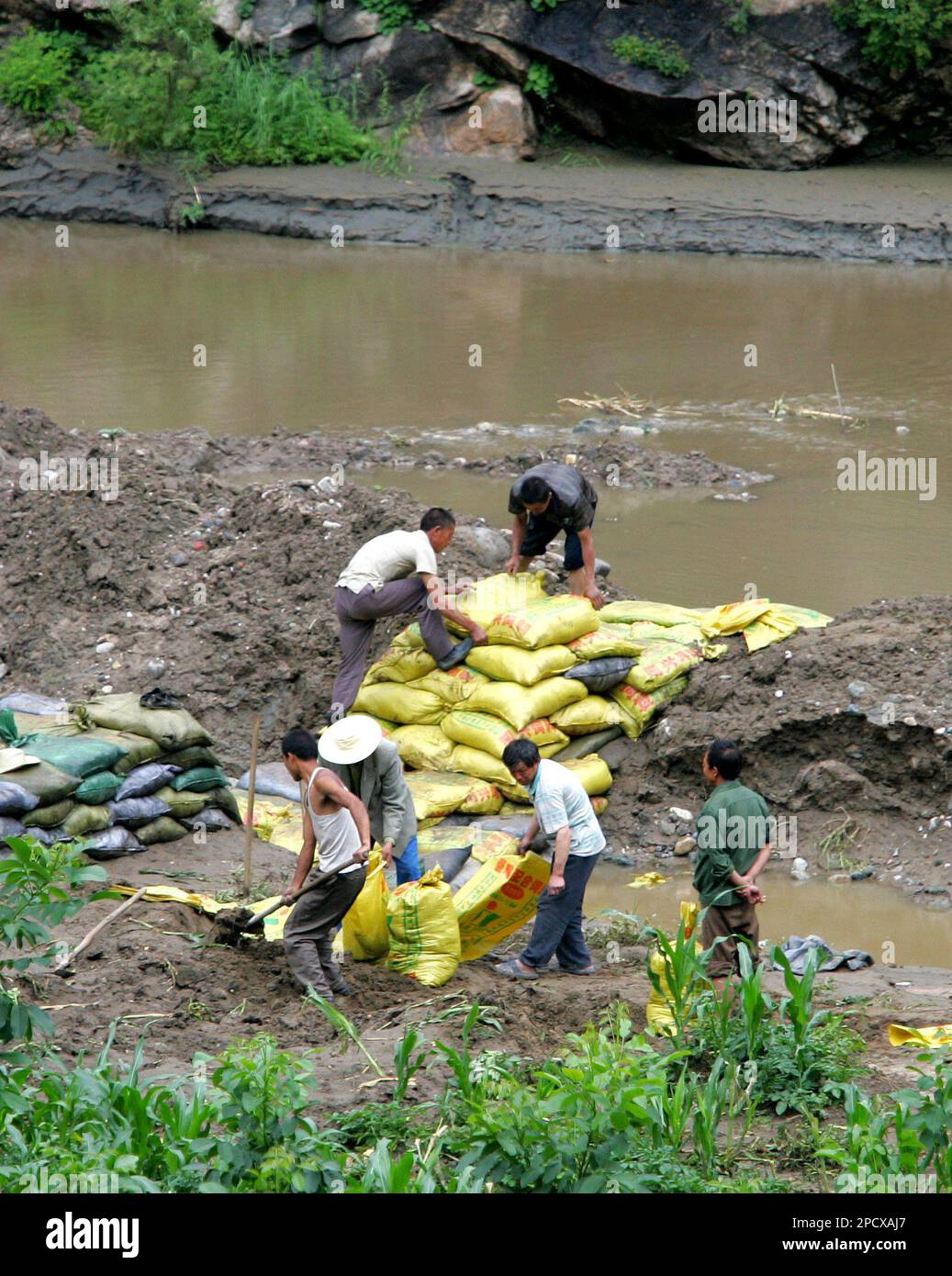 Workers build a dam to redirect the flow of water in the Dasha river ...