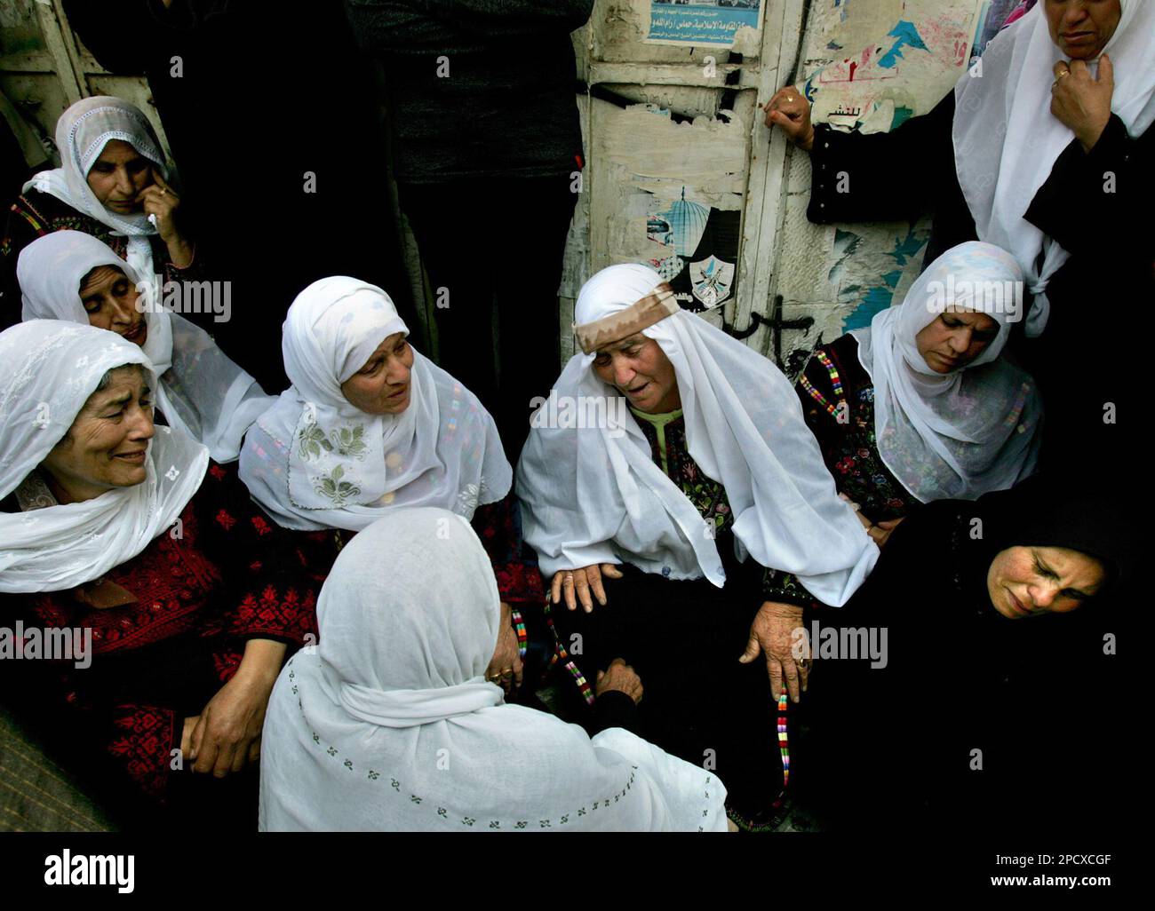 Wearing the traditional Palestinian mourning dresses, Nimah Gabareen, centre with hand band, and ...