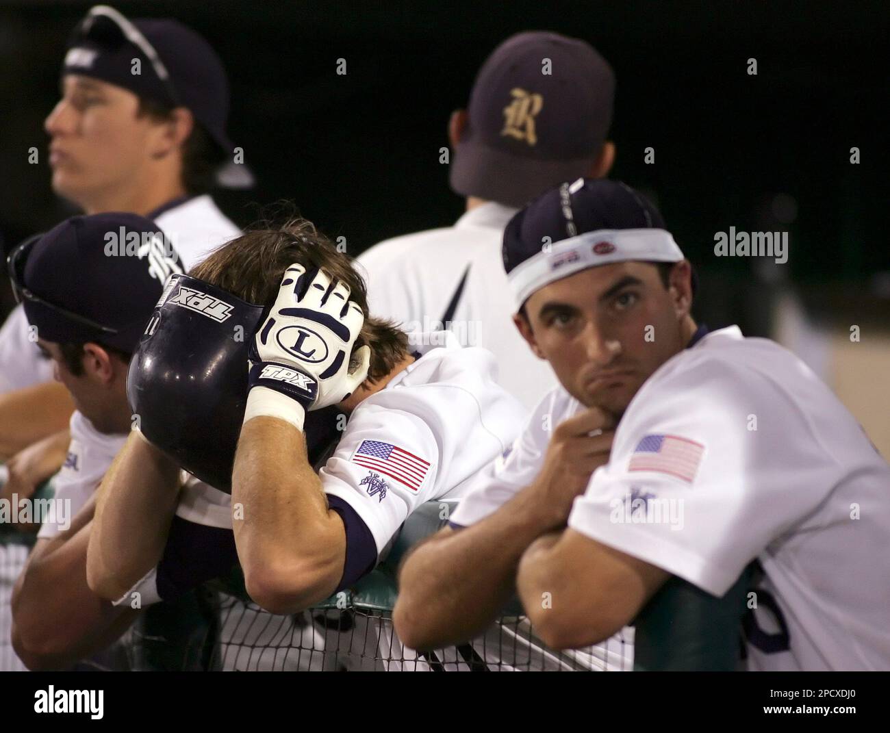 Rice's Danny Lehmann covers his face with a helmet and teammate Chase ...