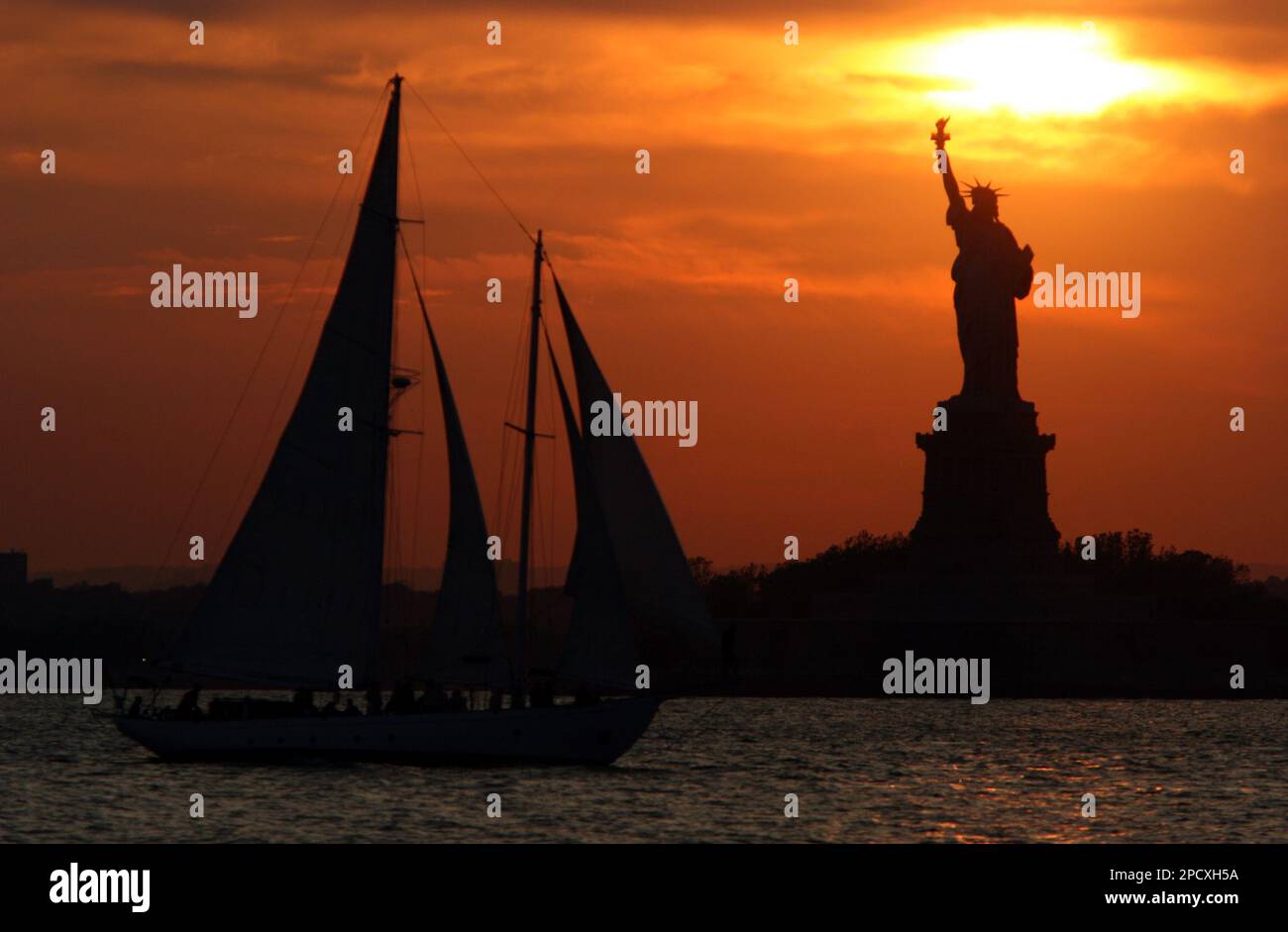 The sun sets behind the Statue of Liberty on the longest day of the ...