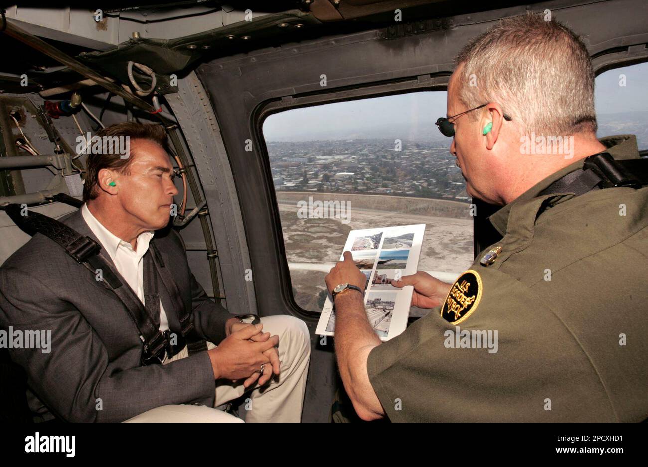 California Gov. Arnold Schwarzenegger, left, looks over a photo locator ...