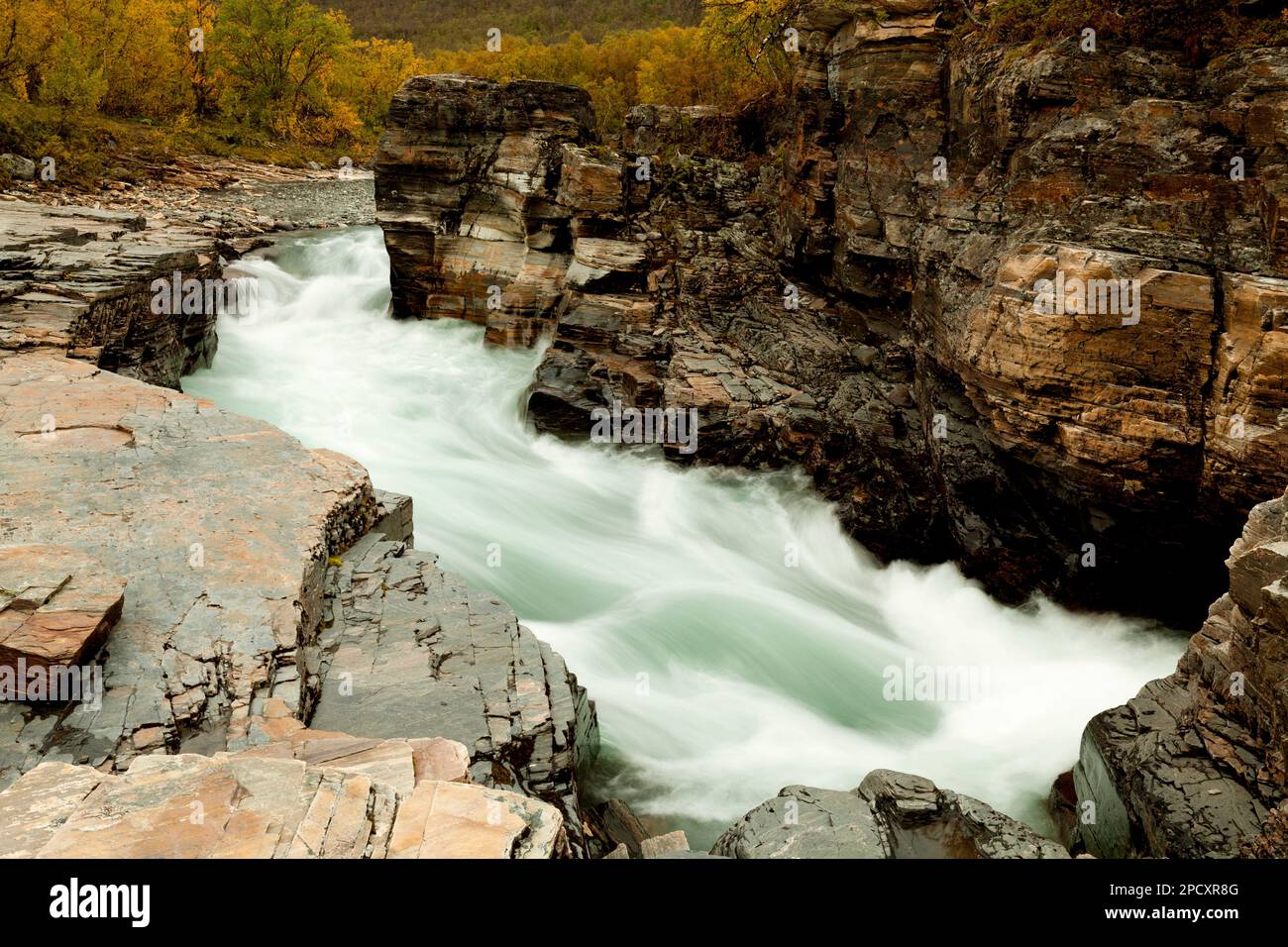 Rocky creek, brook, river up North. Motion in water, high cliffs along ...