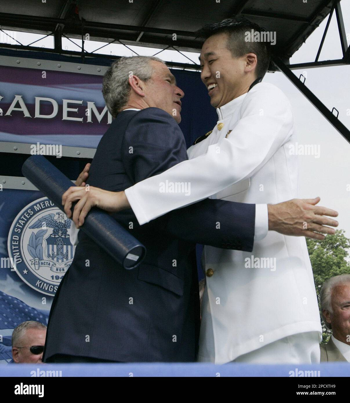 President Bush, left, is embraced by graduate Michael Ho Hahn of Upland ...
