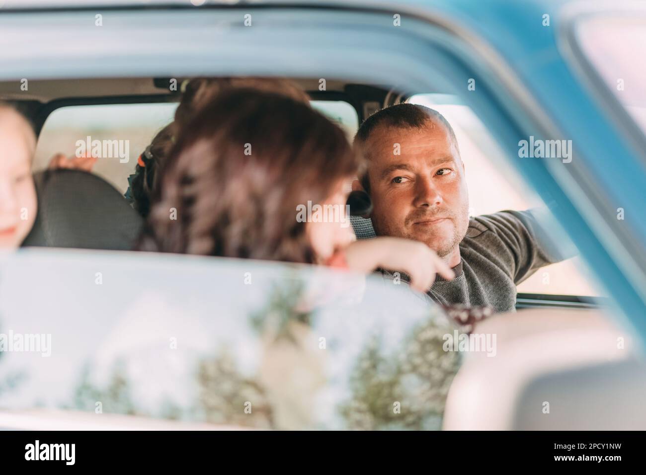 Happy family ride in the car. Young couple in a new car. A man driving ...
