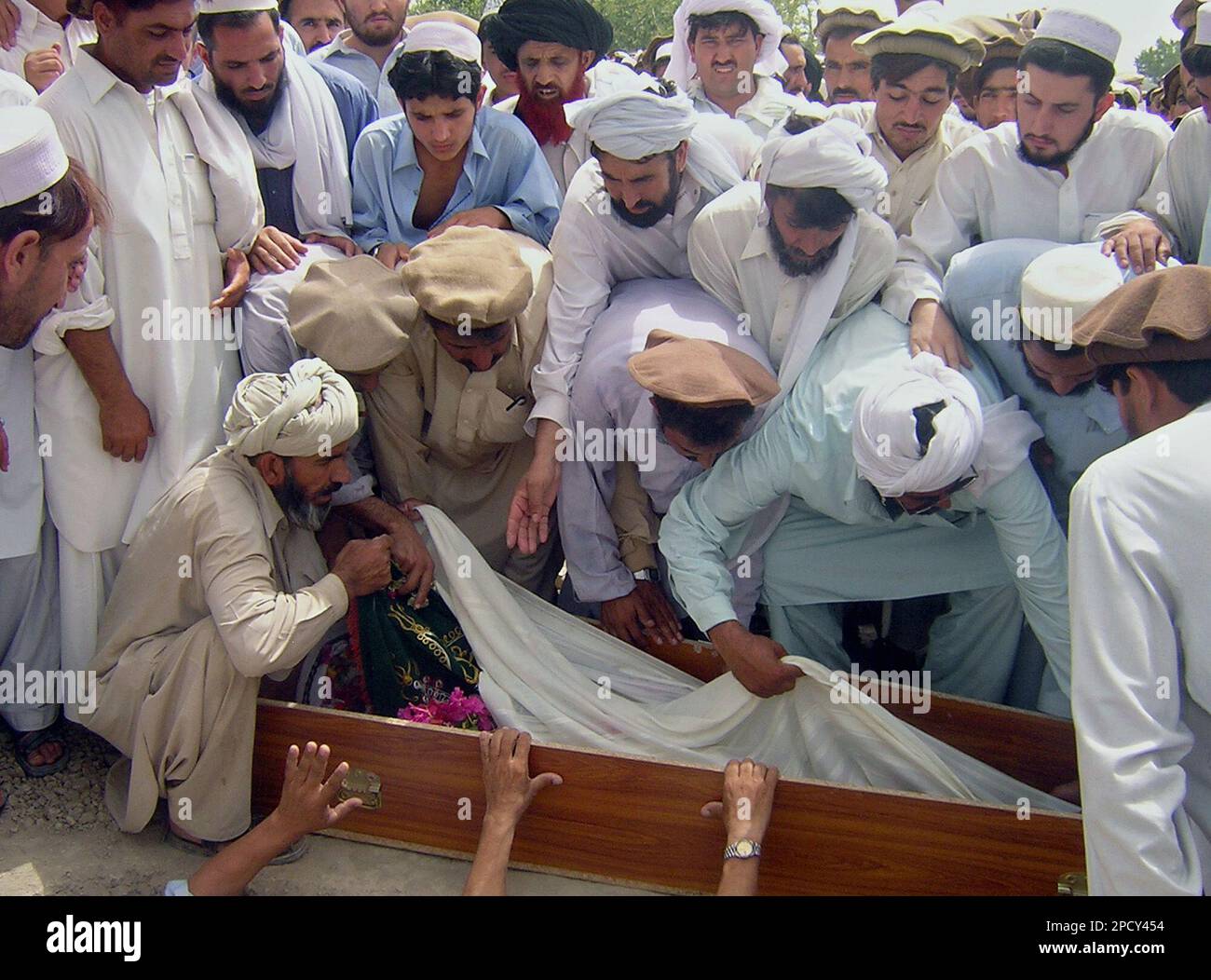 Pakistani tribesmen prepare to lift up the body of slain Pakistani ...