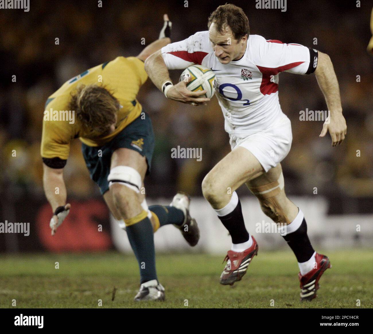 England's Mike Catt runs past Australia's Rocky Elson, left, during ...