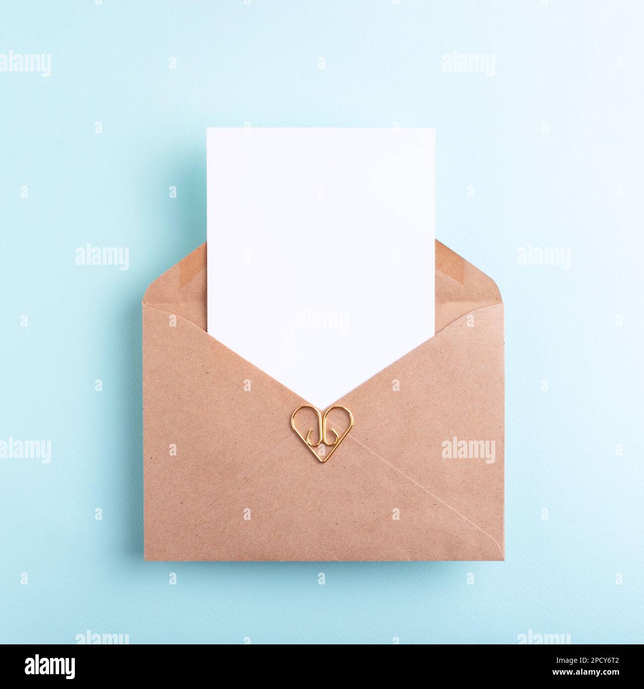 Top view of empty card in kraft envelope on pastel blue background ...