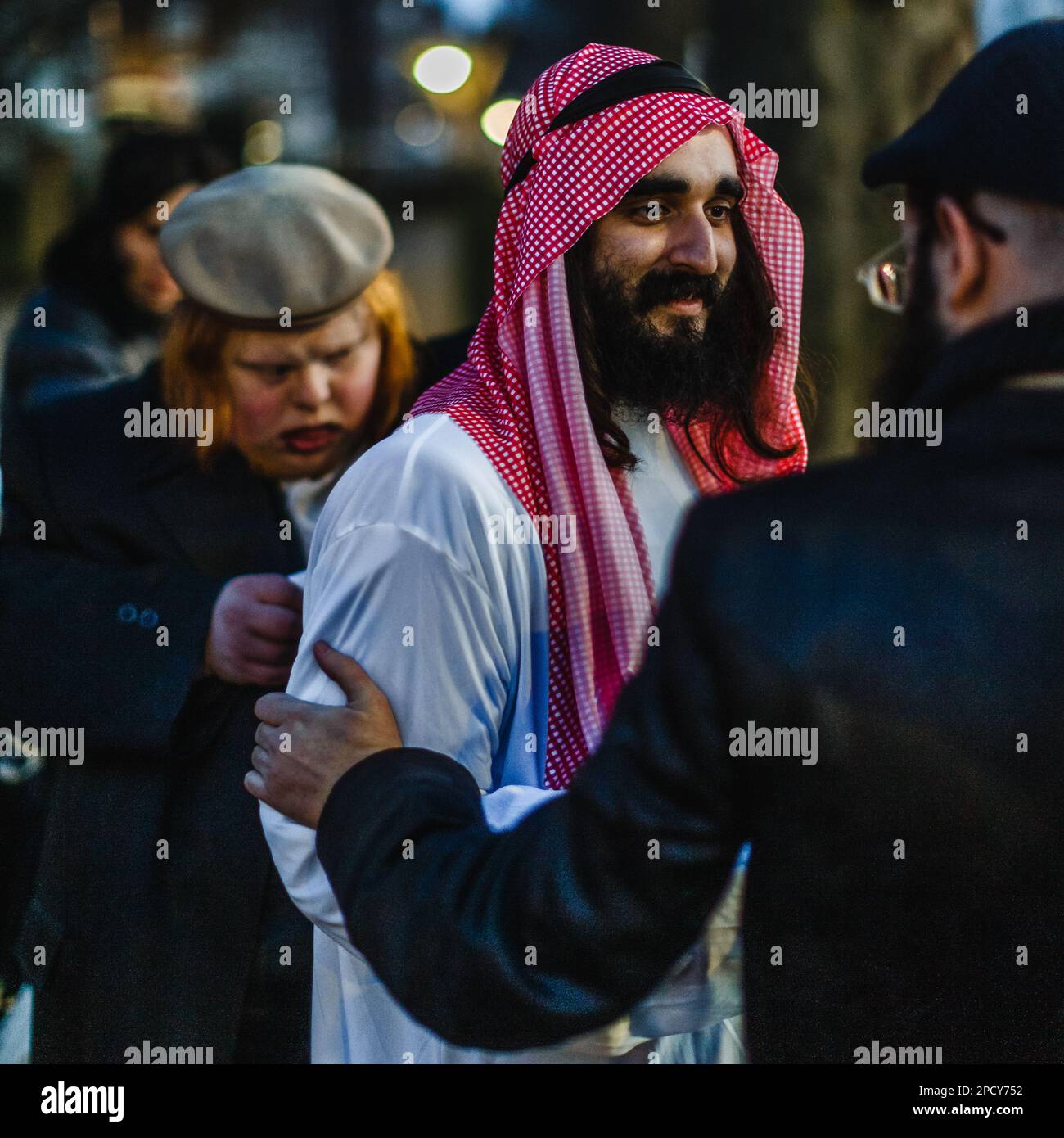 A man dressed as an arab alongside orthodox jews at Purim, the Jewish ...