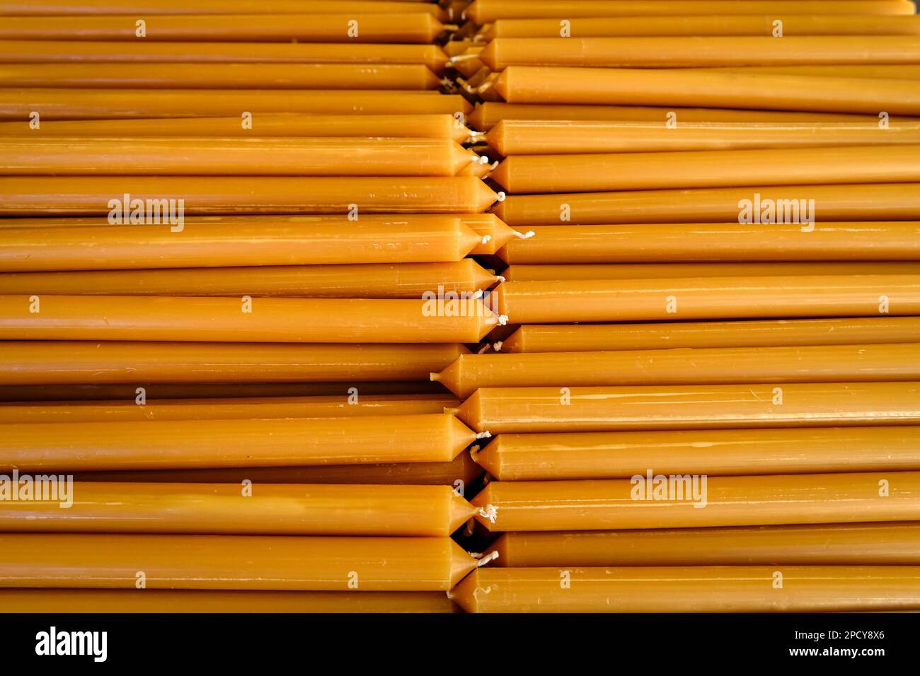 Pile of new yellow wax candles used in churches, close-up Stock Photo ...