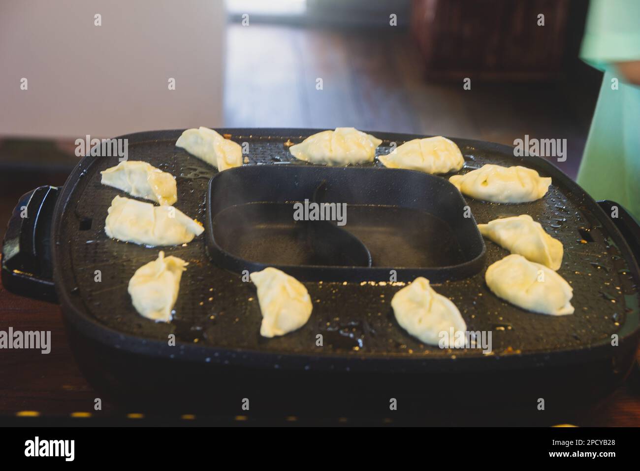 Gyoza or or dumplings snack, close-up of cooking fried Gyoza in a ...