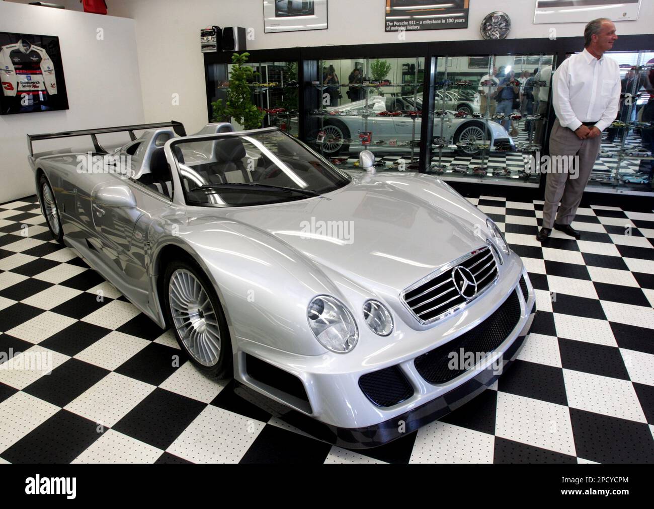 Exotic car dealer Mark Johnston stands next to a Mercedes-Benz AMG CLK ...
