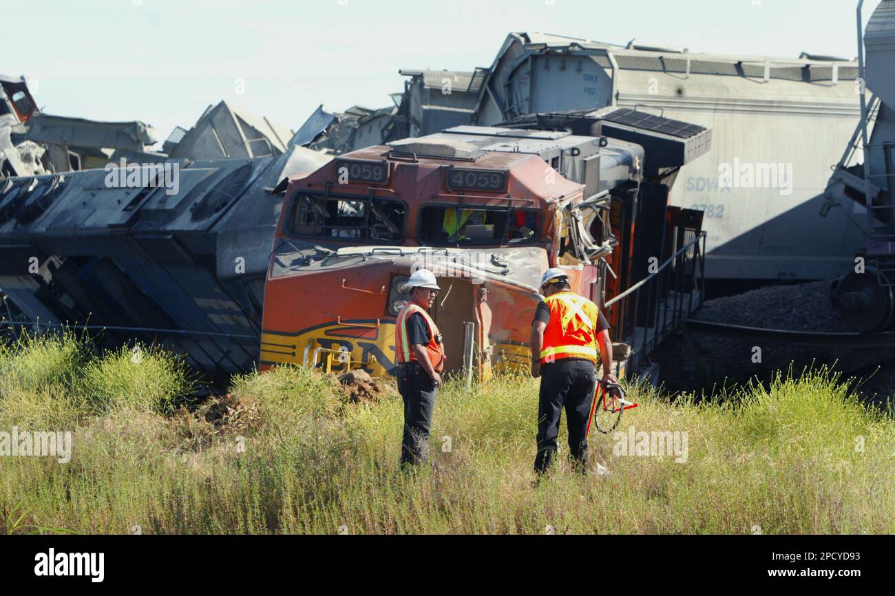 Railroad personnel confer near the wreckage of two Burlington Northern ...