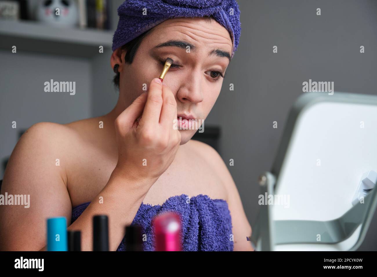 Young transgender man applying eyeshadow Stock Photo - Alamy