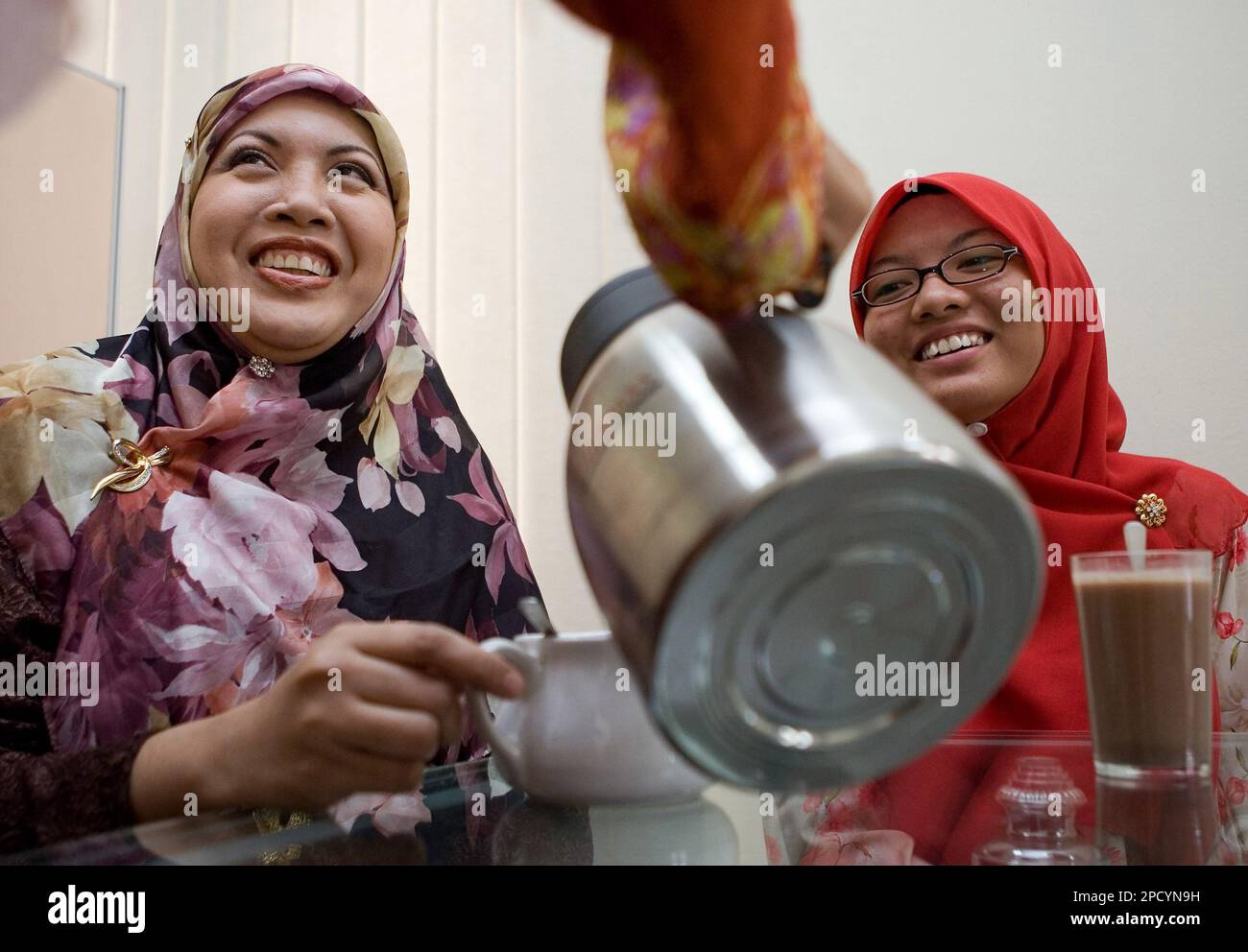 Aida Melly Tan Abdullah, left, chats with her working staff during a ...
