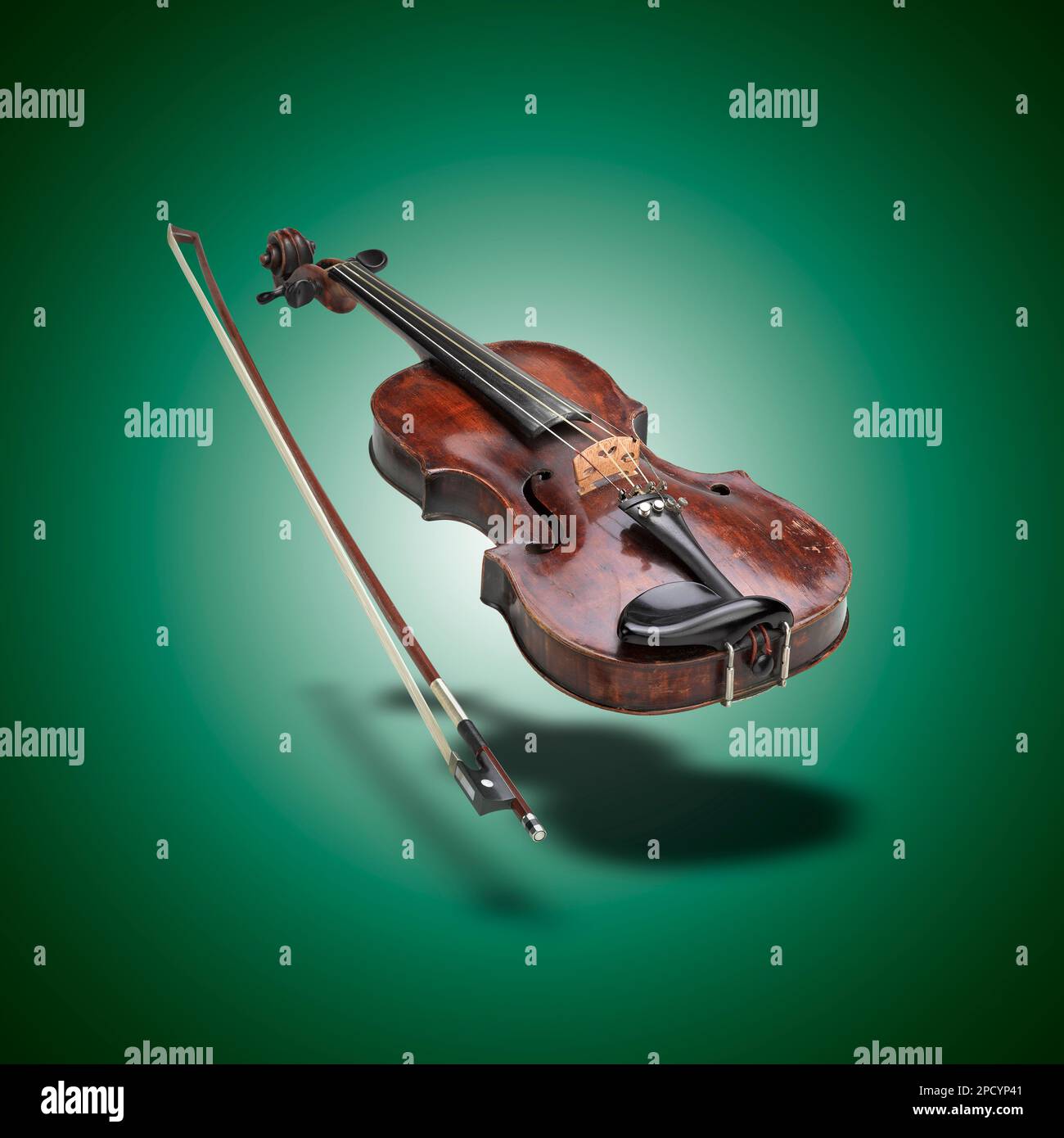 Floating classical violin instrument with shadows on green gradient ...