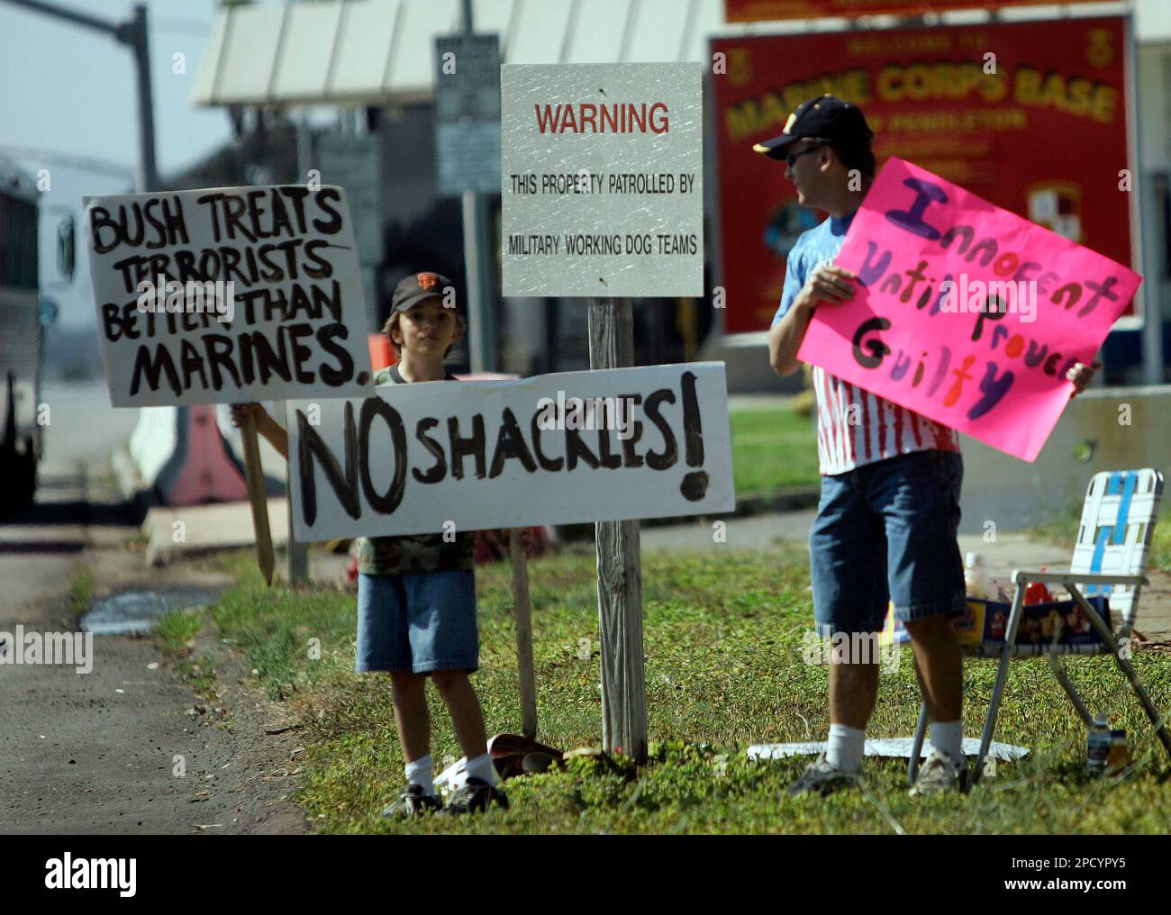 Brian Bruce and his eleven-year-old son, Brian Bruce Jr., hold up signs ...
